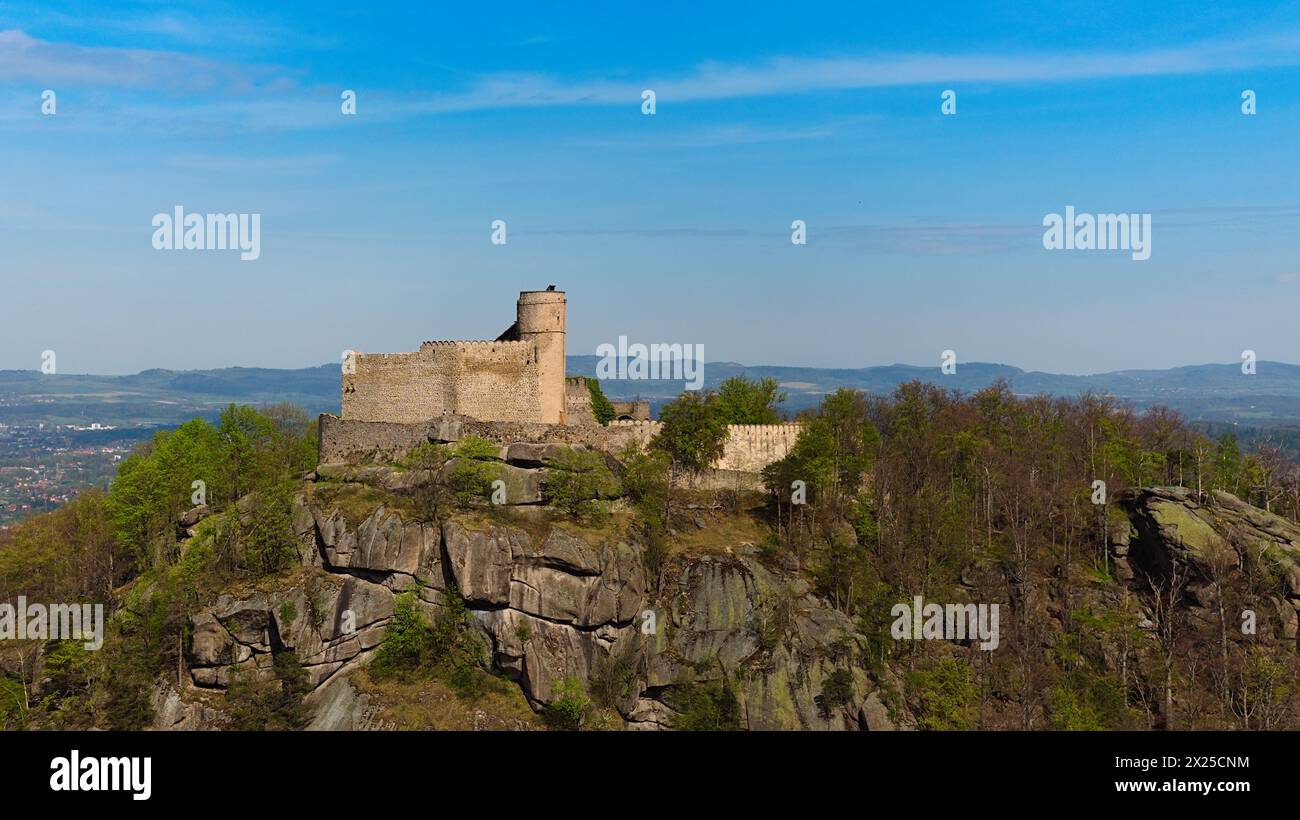 An aerial view captures the medieval Chojnik Castle atop a mountain in ...