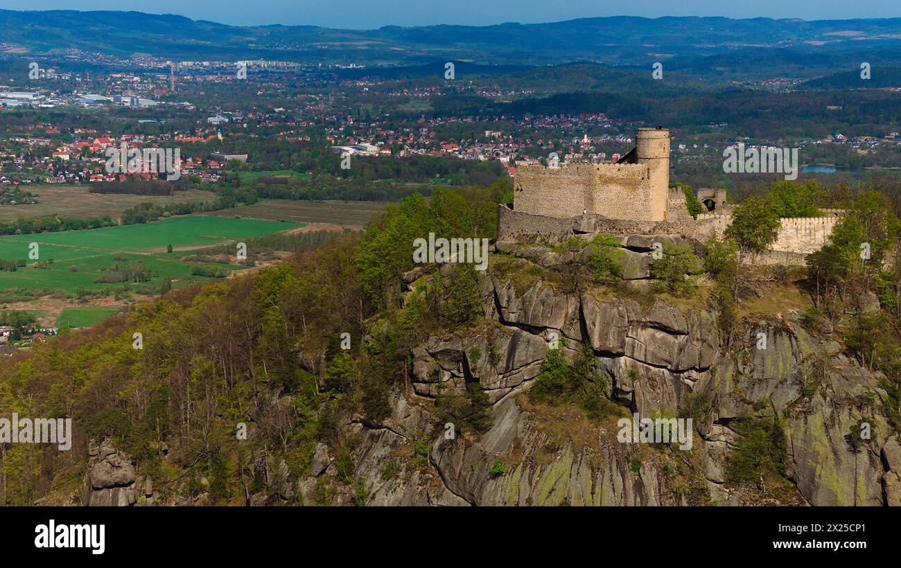 An aerial view captures the medieval Chojnik Castle atop a mountain in ...
