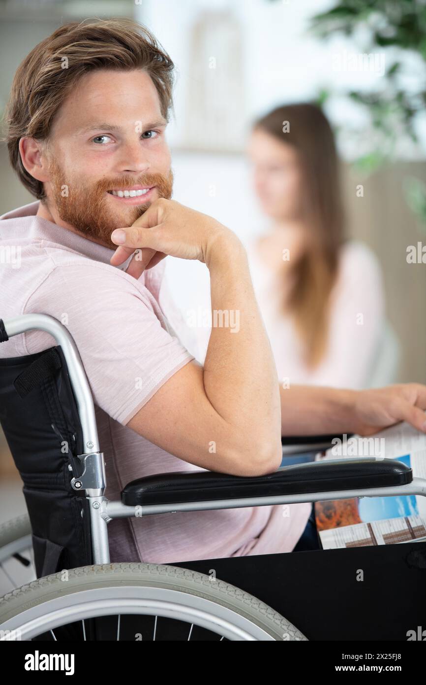happy man sitting in wheelchair at home Stock Photo - Alamy