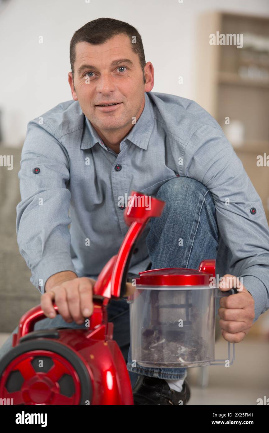 man dismantling vacuum cleaner to empty out the dust Stock Photo - Alamy