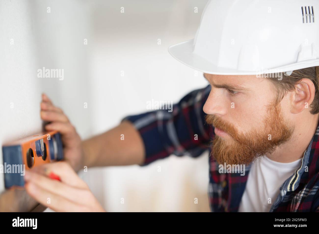 handyman measuring angle of wall with level Stock Photo - Alamy
