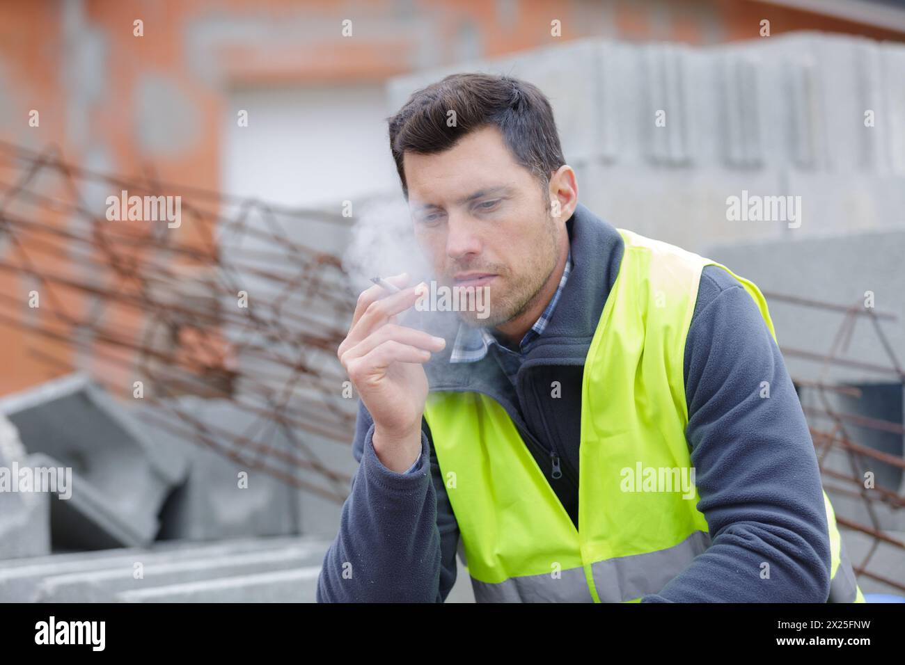 builder smoking cigarette on construction site Stock Photo - Alamy