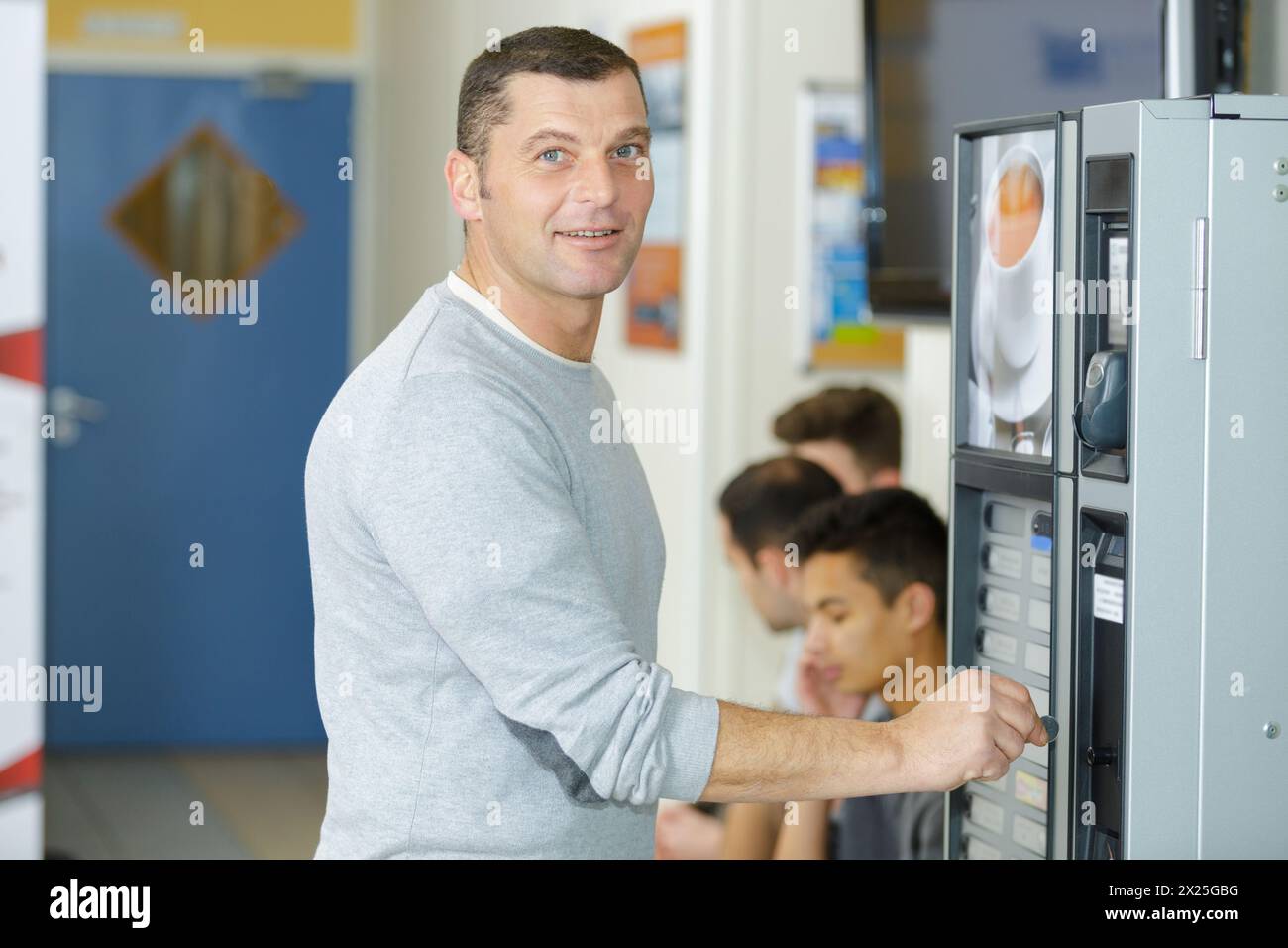 man buying a drink from a vending machine Stock Photo - Alamy