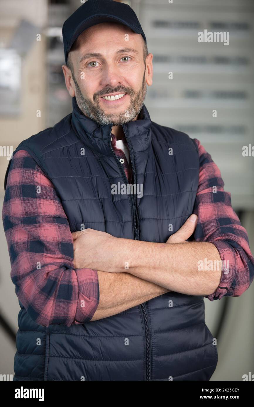 handsome mechanic man smiling with crossed arms Stock Photo - Alamy