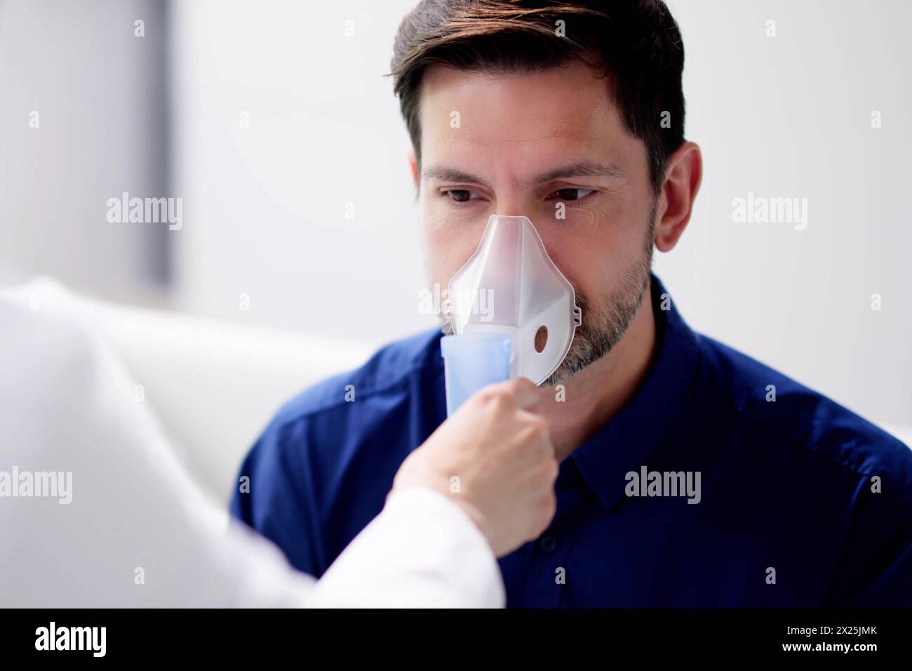 Doctor using nebulizer mask to help COPD patient breathe Stock Photo ...
