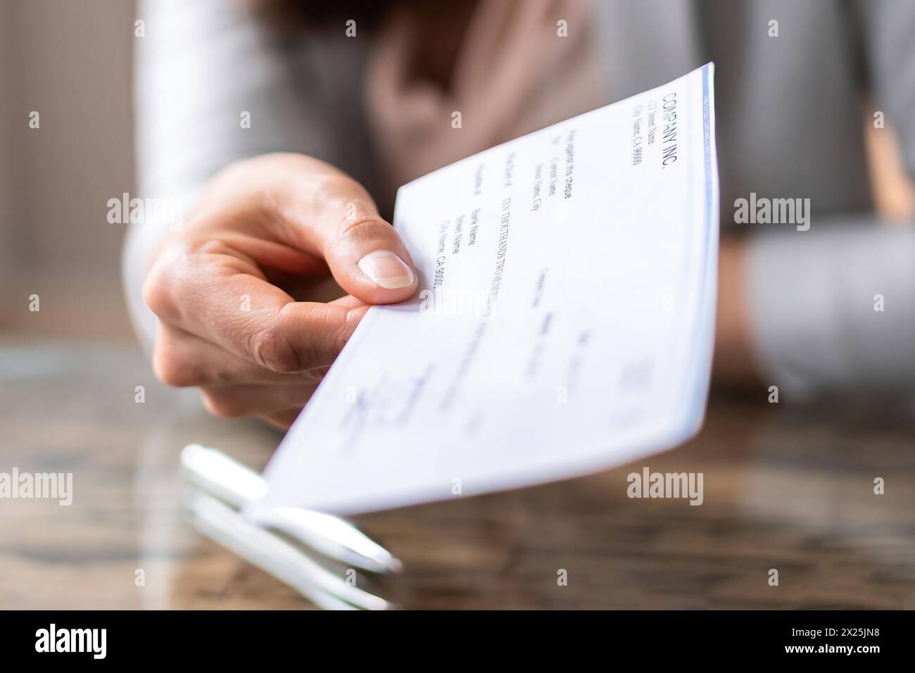 Hand giving paycheck, check, cheque in transaction concept Stock Photo ...