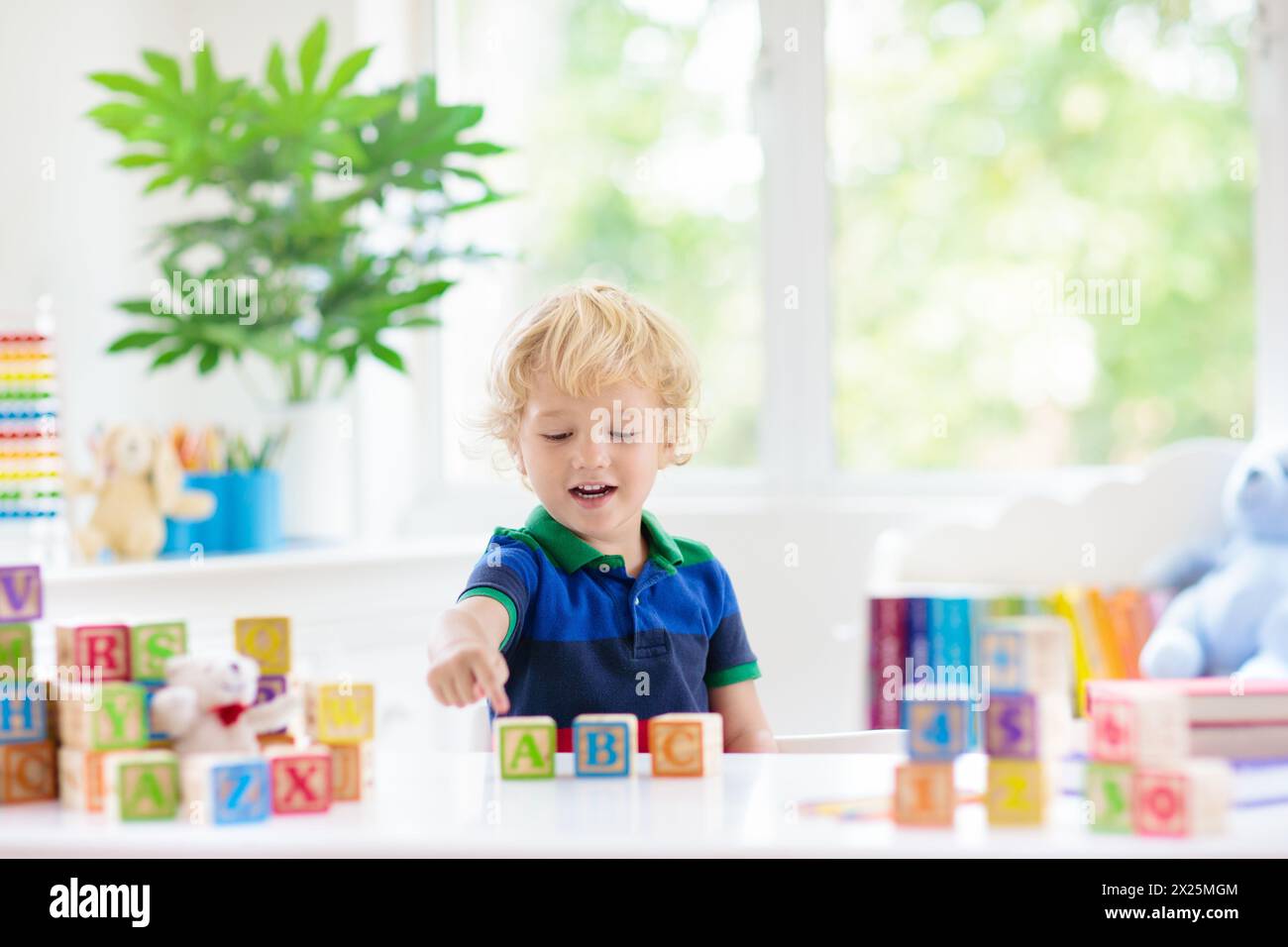 Child learning letters and numbers. Kid with colorful wooden abc blocks ...