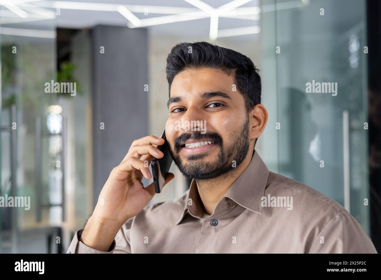 A cheerful professional man is engaged in a friendly phone conversation ...