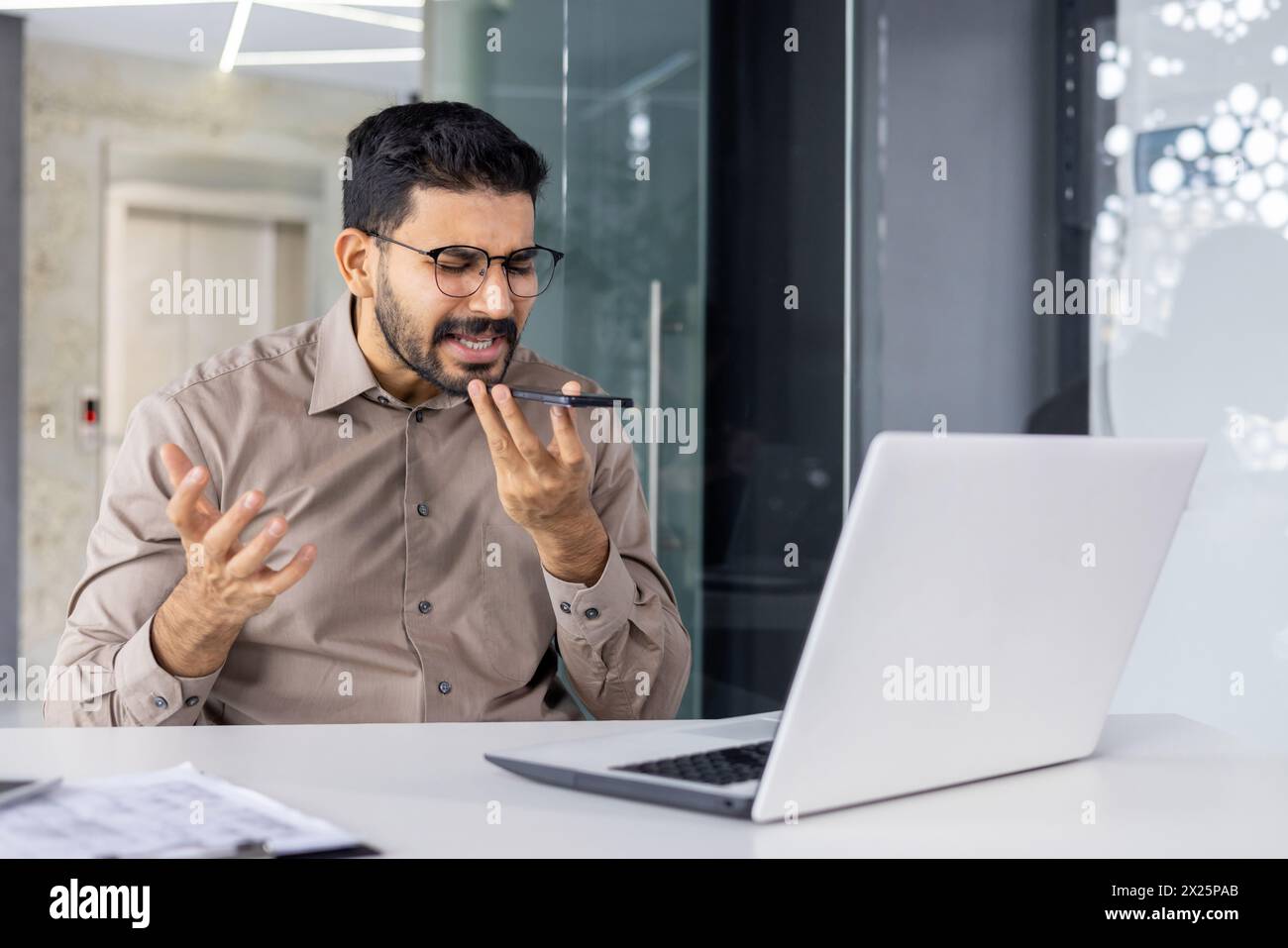 A businessman experiences frustration while talking on his smartphone ...