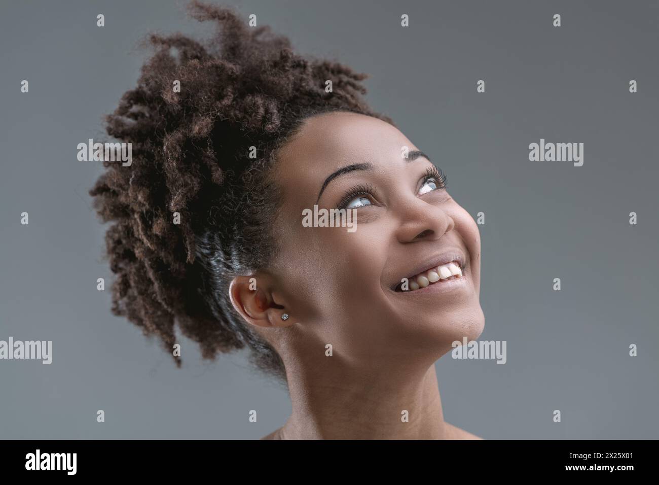 woman's cheerful countenance is captured as she looks upward, eyes ...