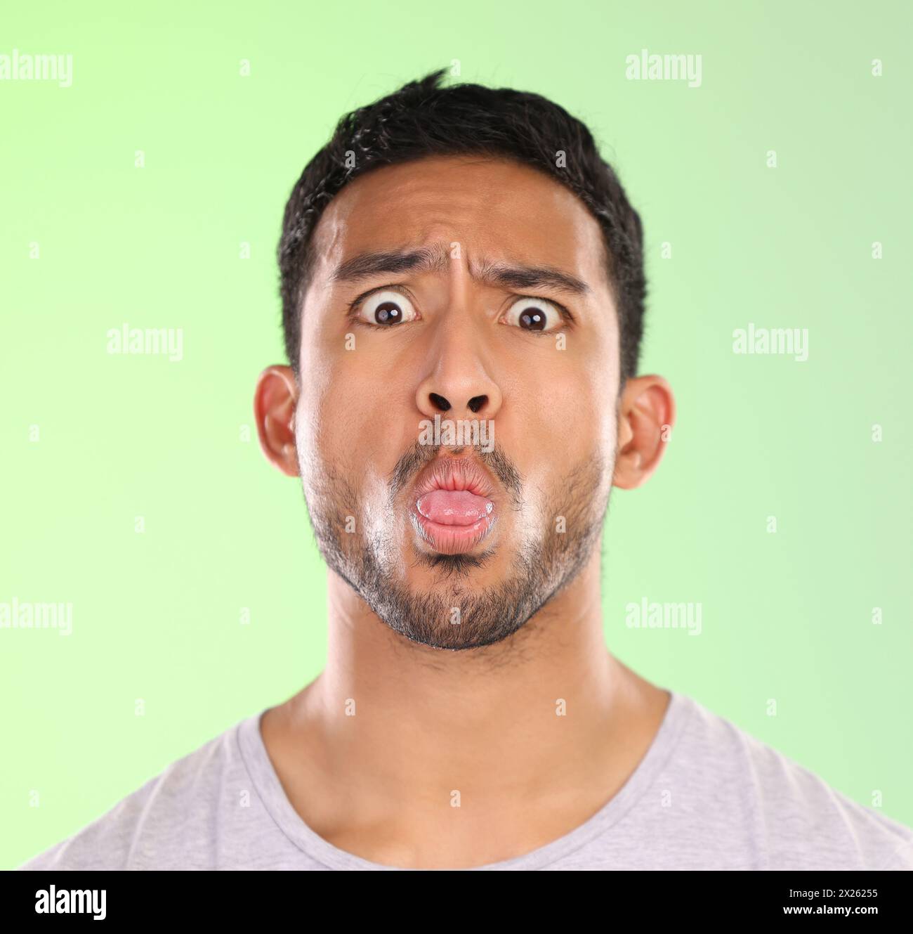 Man, portrait and humor in studio, tongue and goofy comic or funny face ...