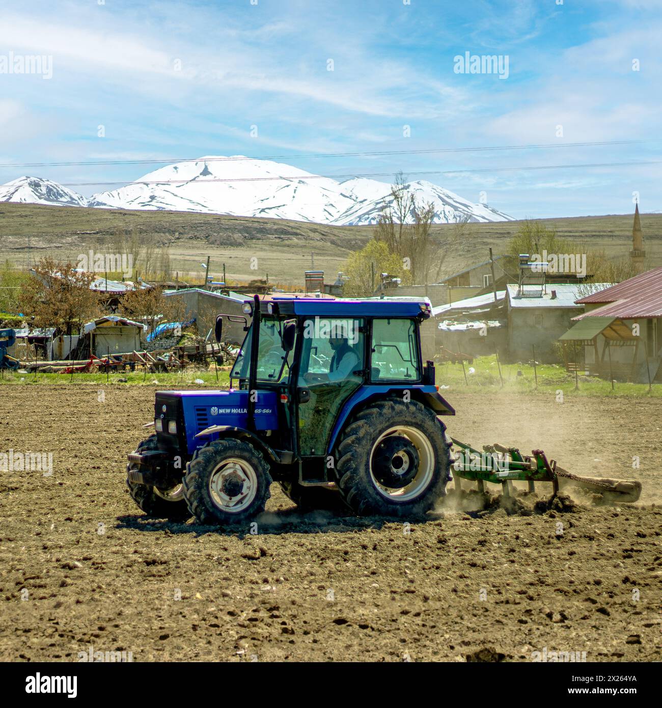 Farming: a powerful tractor tills the earth, readying the soil for a ...