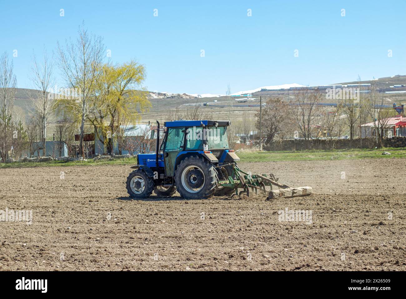 Farming: a powerful tractor tills the earth, readying the soil for a ...