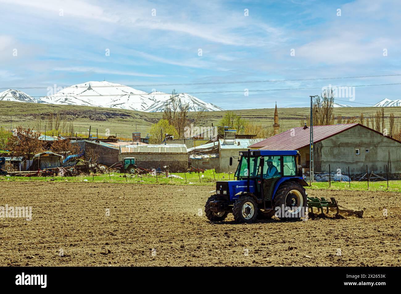 Farming: a powerful tractor tills the earth, readying the soil for a ...