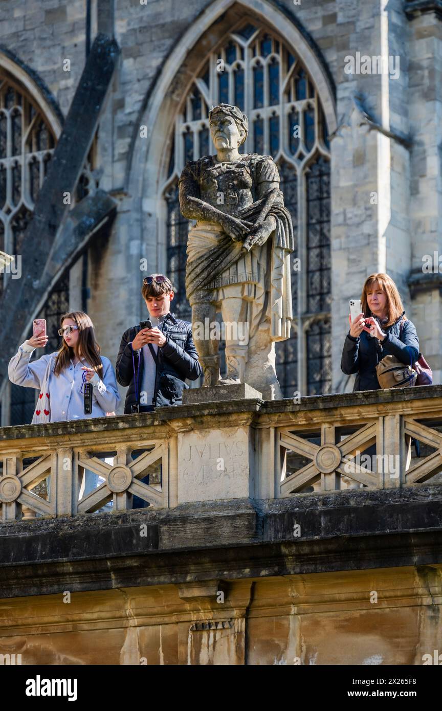 Bath, UK. 20th Apr, 2024. Visitors (and a statue of Julius Caesar) to ...