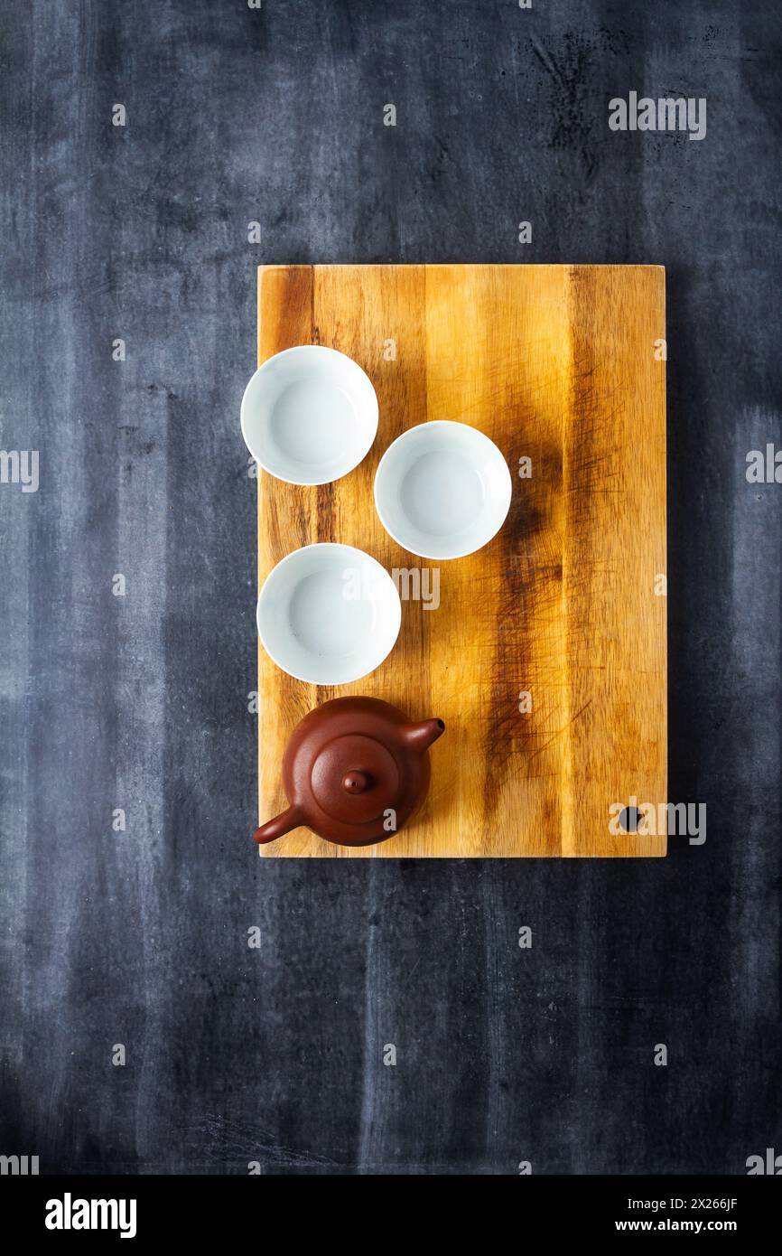 Teapot and cups with wooden cutting board o black chalkboard background ...
