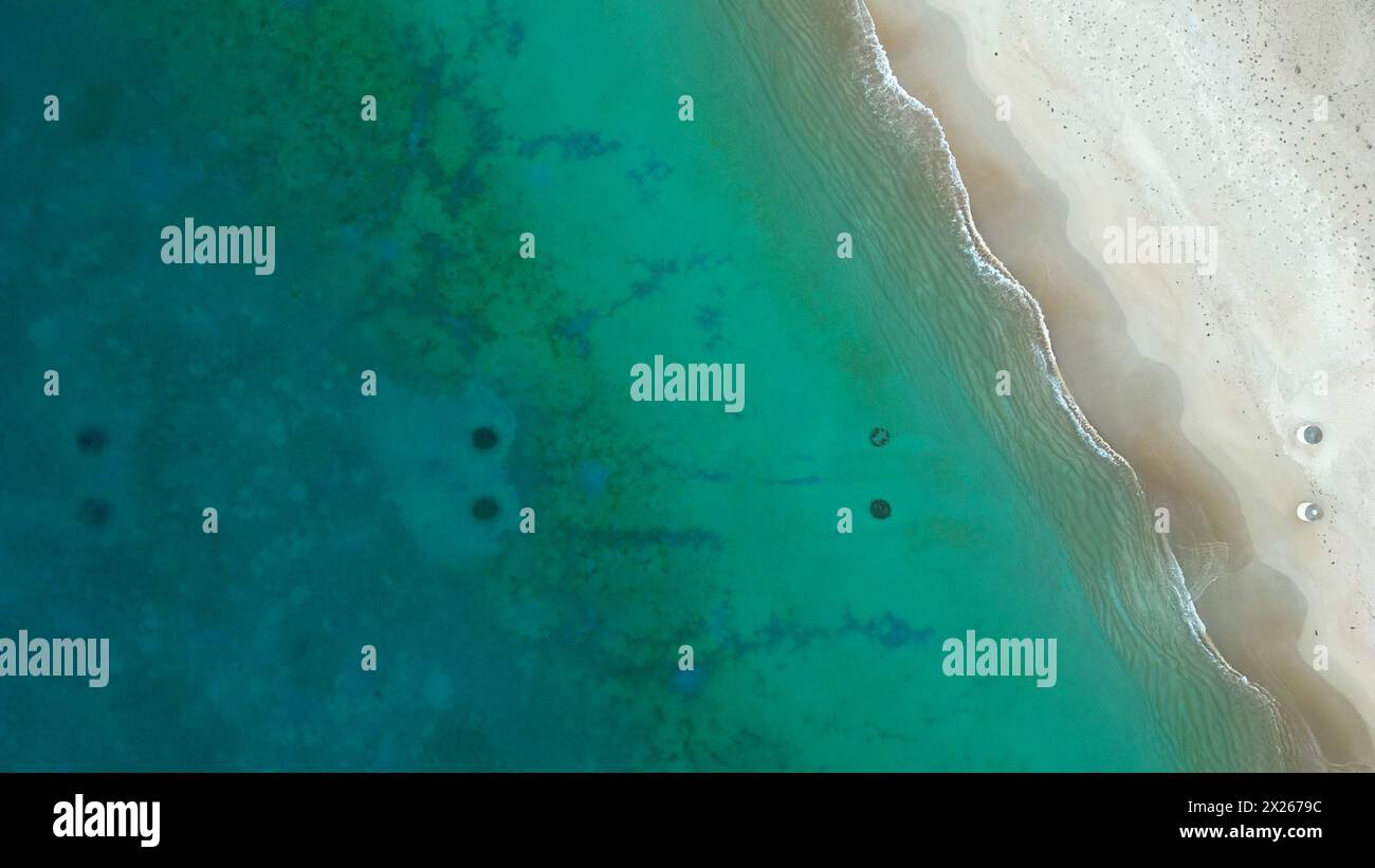 Aerial view of old jetty piles leading out into a calm blue sea Stock ...