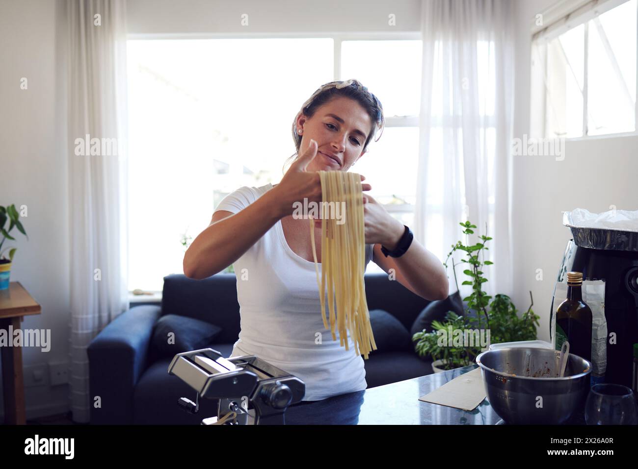 Woman, handmade pasta and preparing in kitchen with dough for spaghetti ...