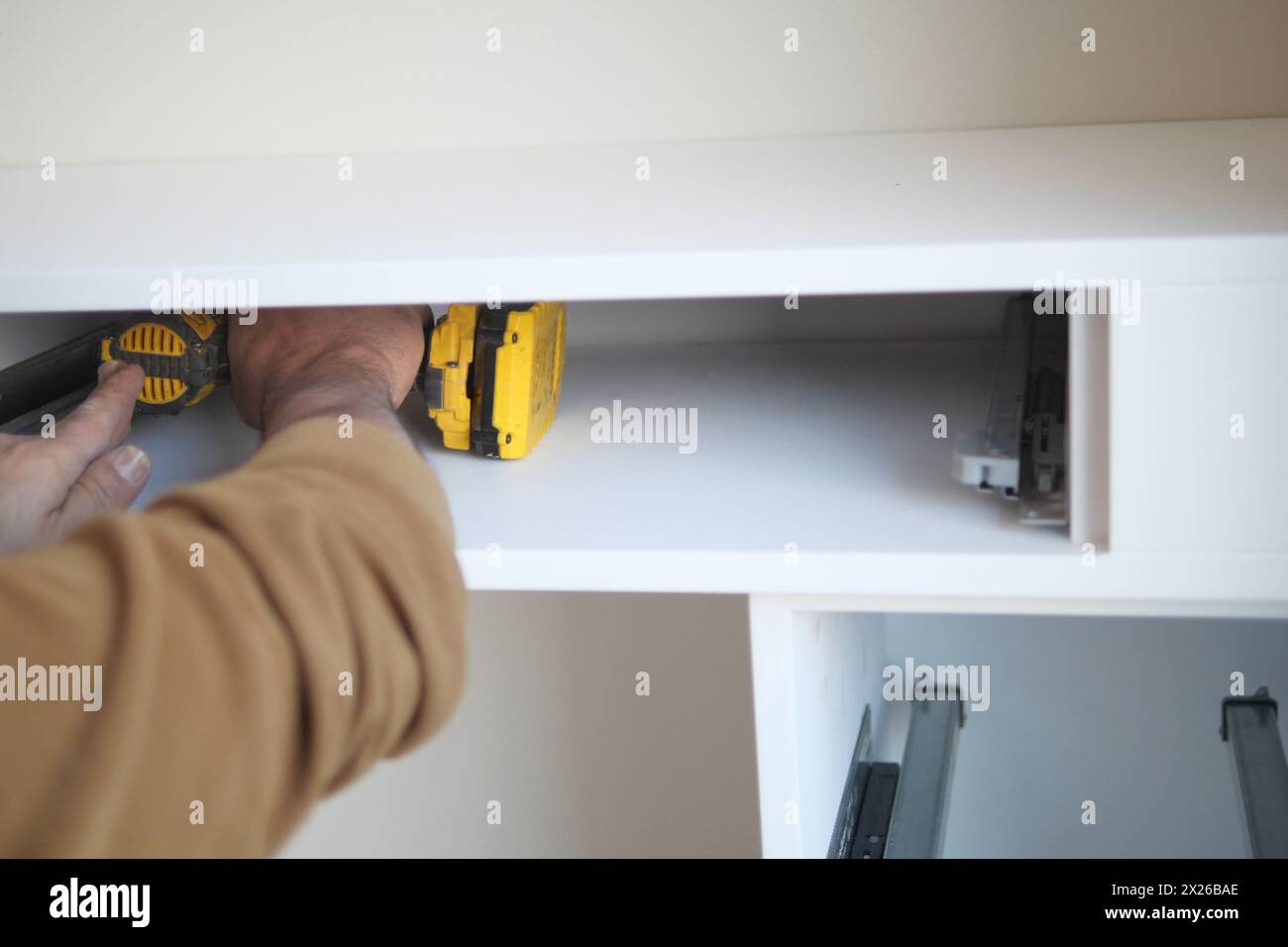Man installing wooden shelves on brackets wall installing a shelf Stock ...