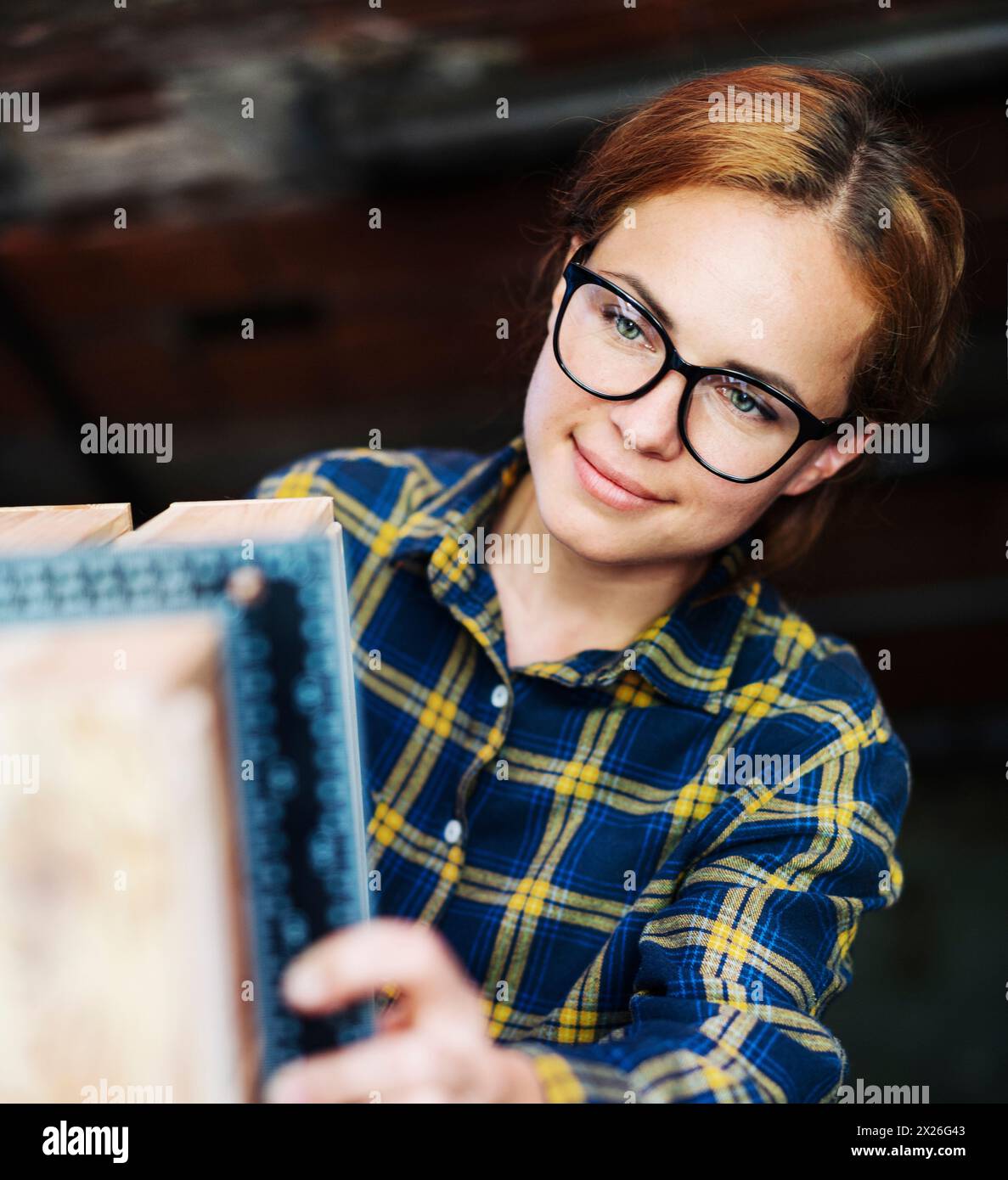 Woman worker measuring sample of wooden furniture while working at ...