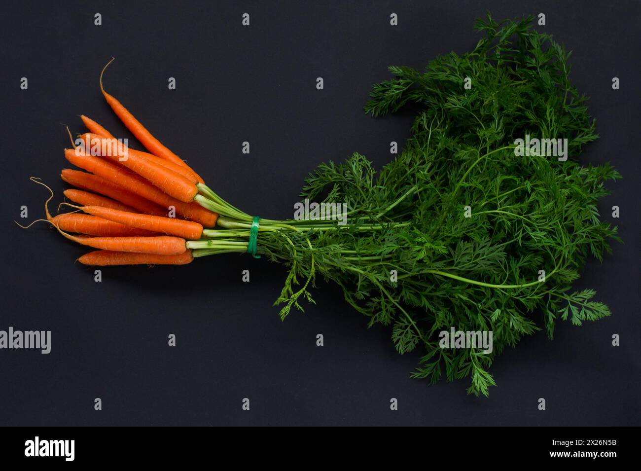 A bunch of fresh raw carrots on a black background Stock Photo - Alamy
