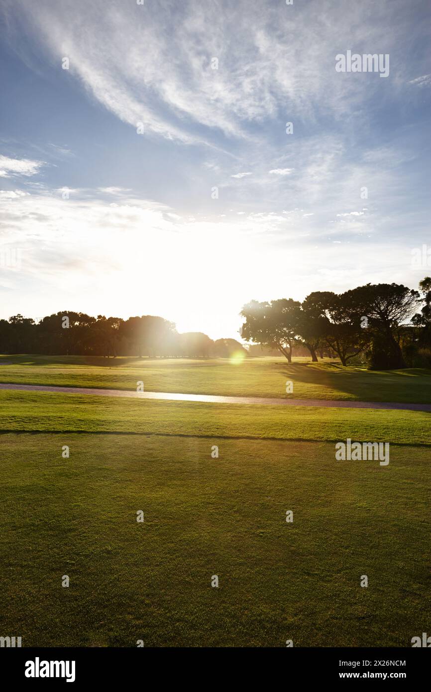 Grass, sky and trees on golf course with sunset, clouds and natural ...