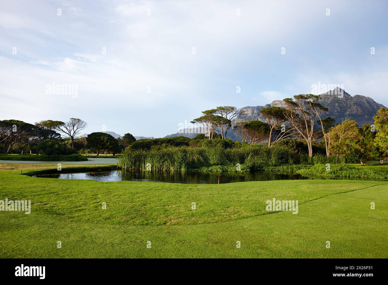 Grass, sky and trees on golf course with lake, mountain and natural ...