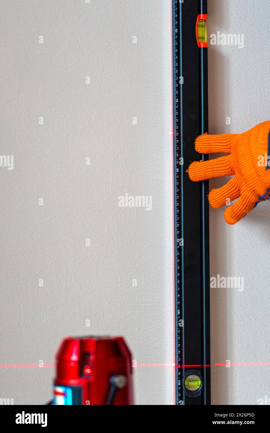 Worker and Bubble,laser level. lines on the wall. measuring with red ...