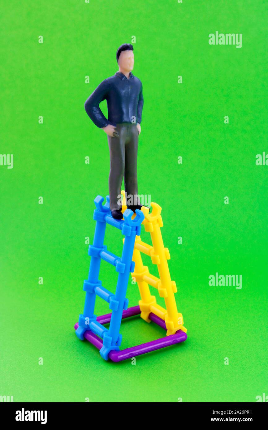 Man on two ladders leaning against each other Stock Photo - Alamy