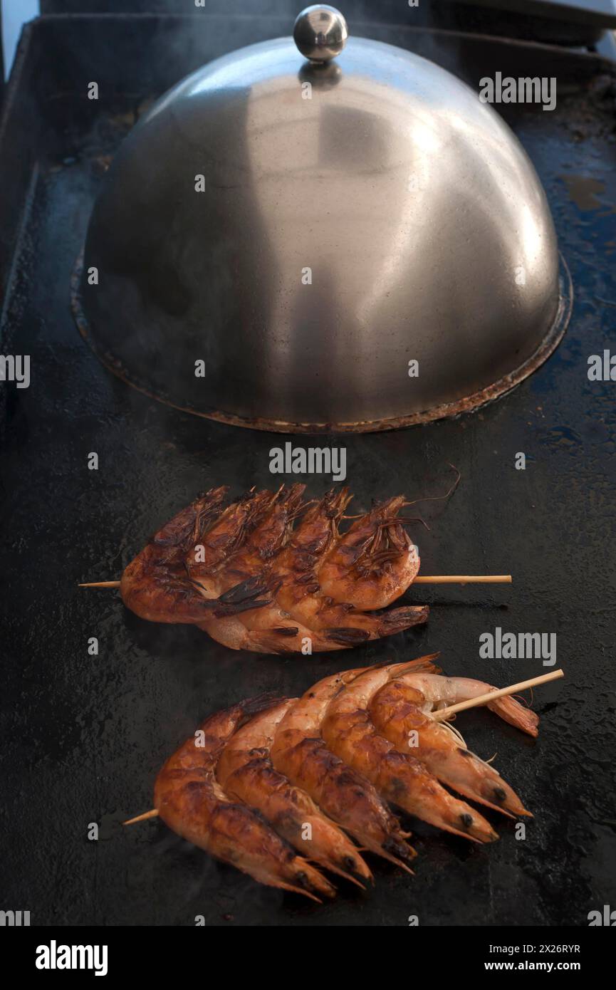 Spit-roasted prawns on a plancha, gas grill, stainless steel cooking ...