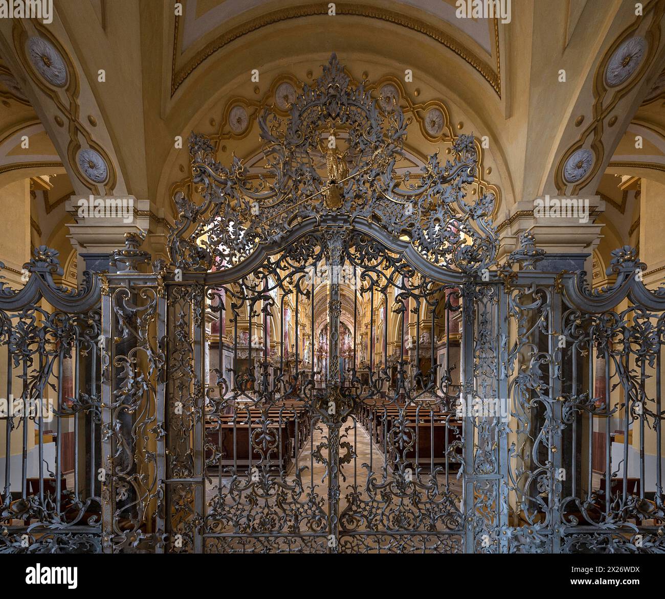 Artistic, wrought-iron gate in front of the interior of Ebrach Abbey ...