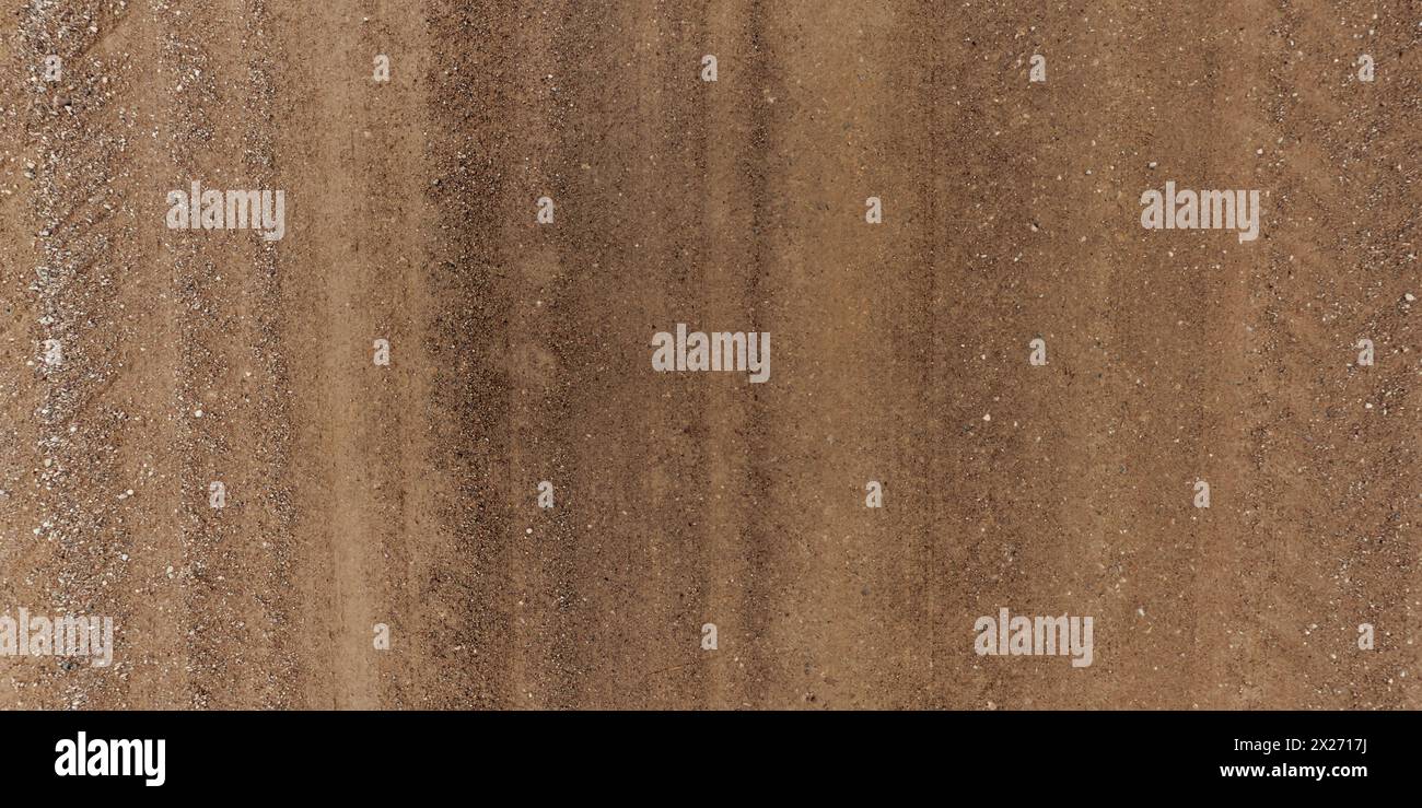 view from above on texture of wet muddy road with tractor tire tracks ...