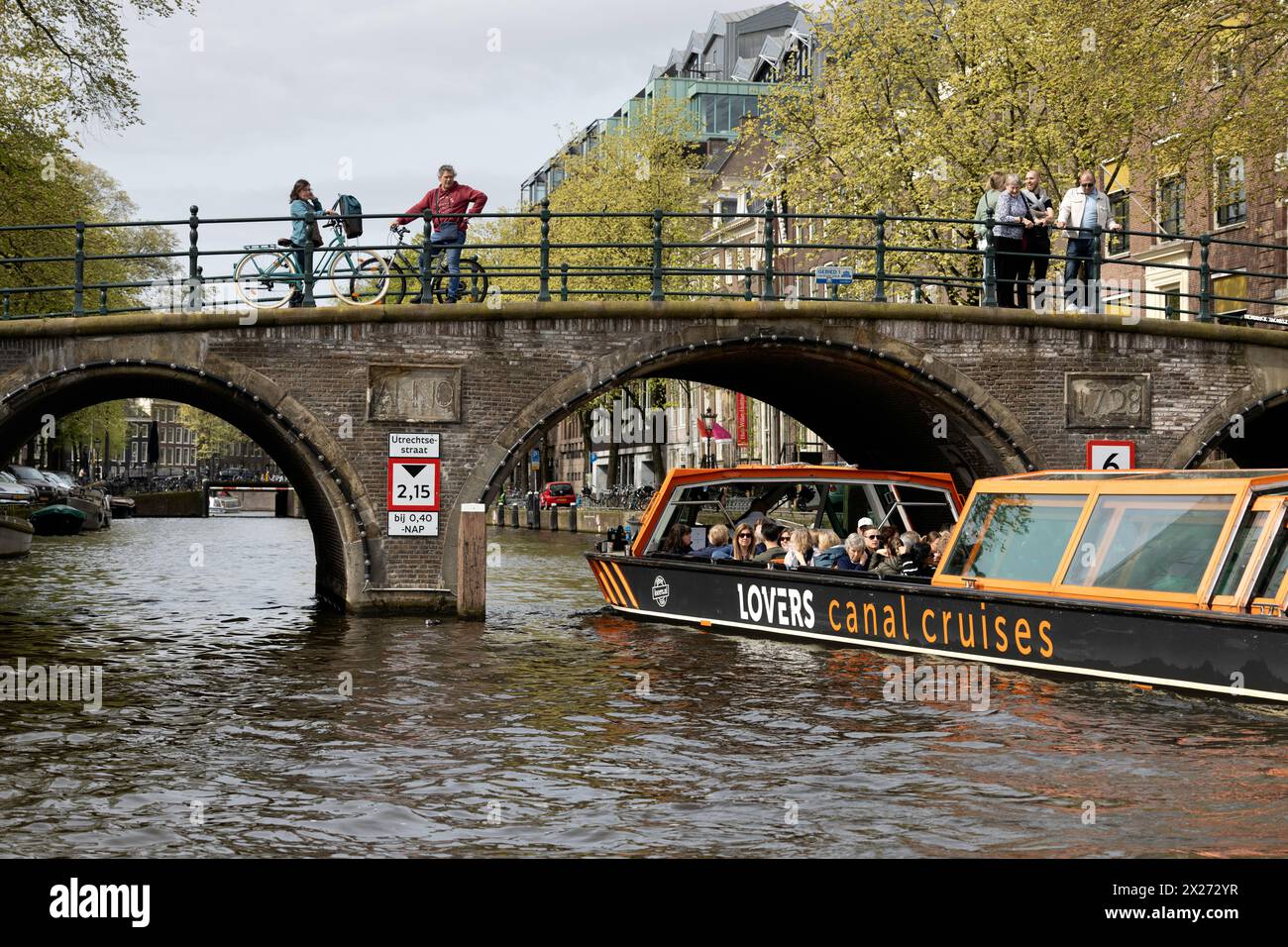 Amsterdam canal cruise boat passing under bridge Stock Photo - Alamy