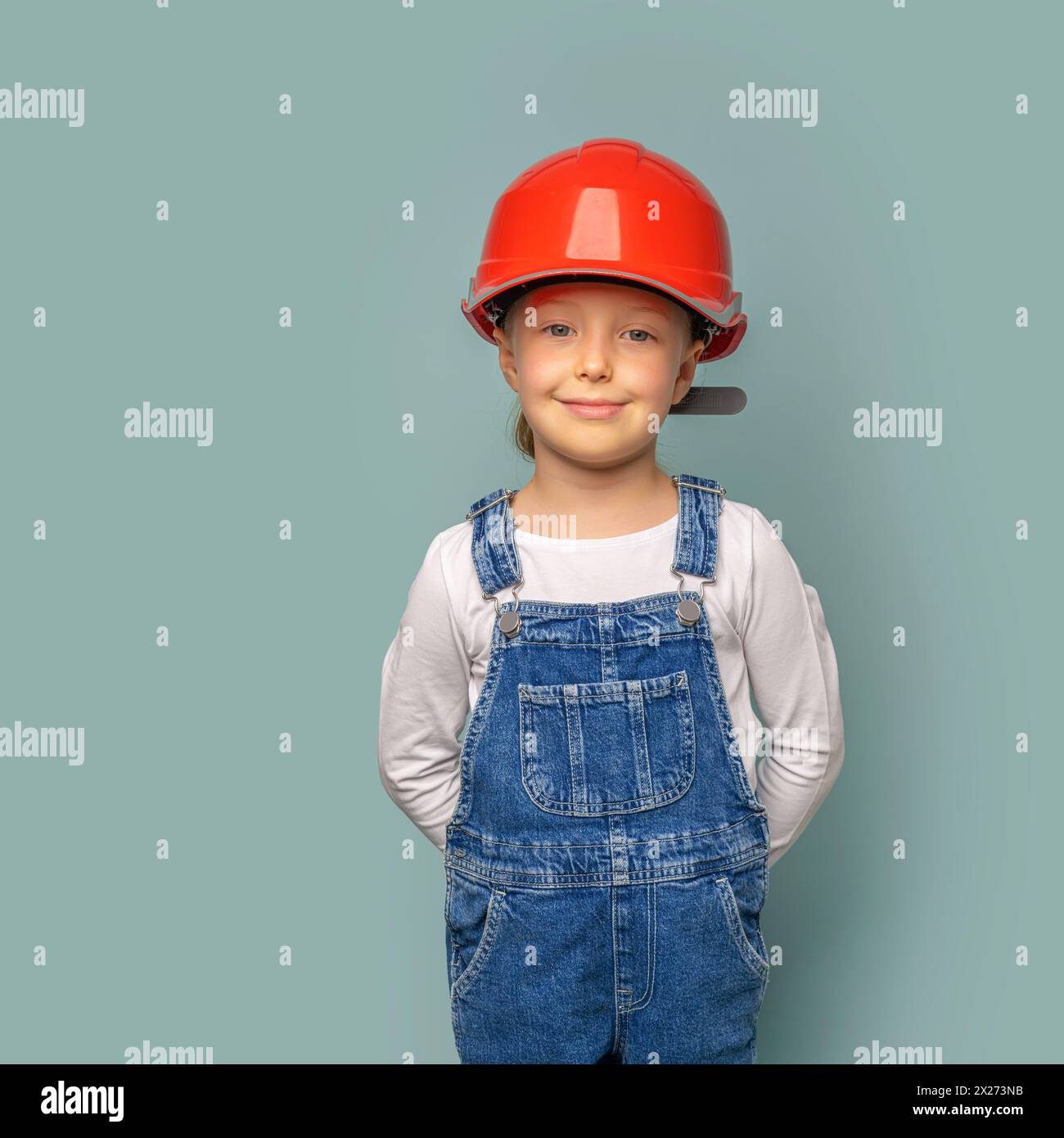 Little girl worker in a safety helmet with a tool Stock Photo - Alamy