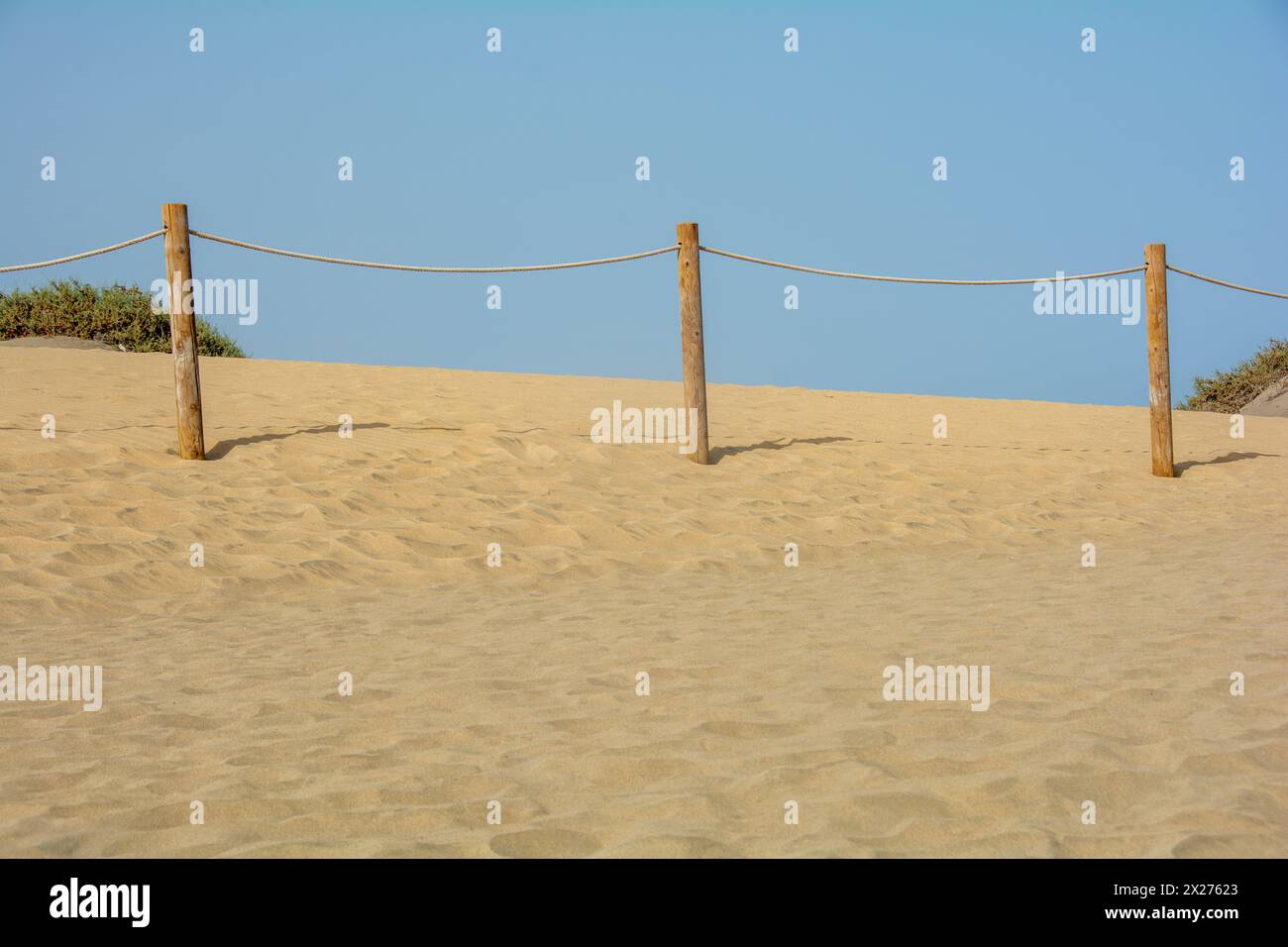 Sand dunes of Maspalomas with a fence made of wooden posts and ropes ...