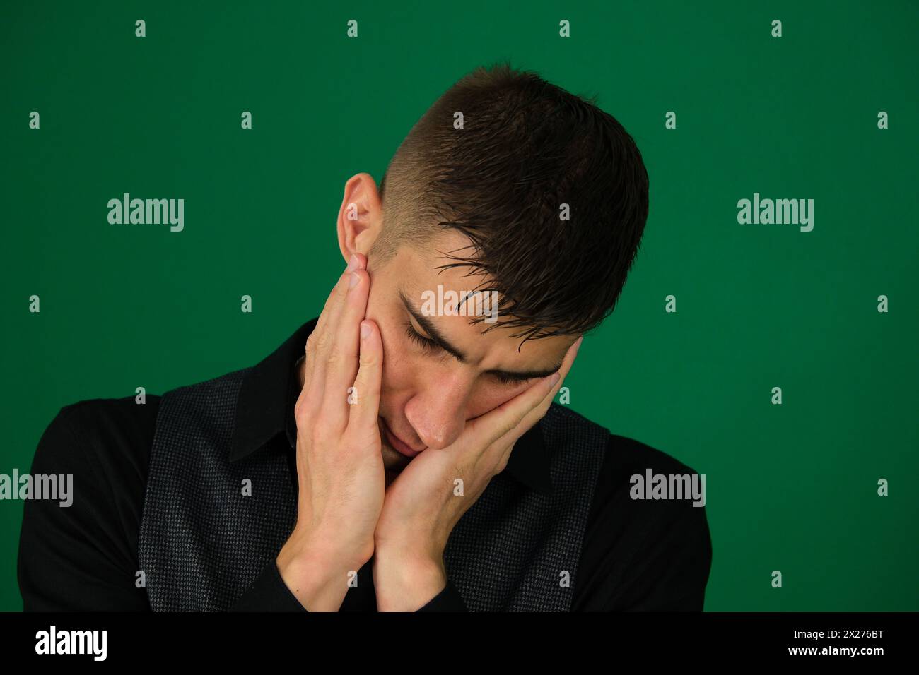 Tired men. Portrait of tired young men holding his hands on face while ...