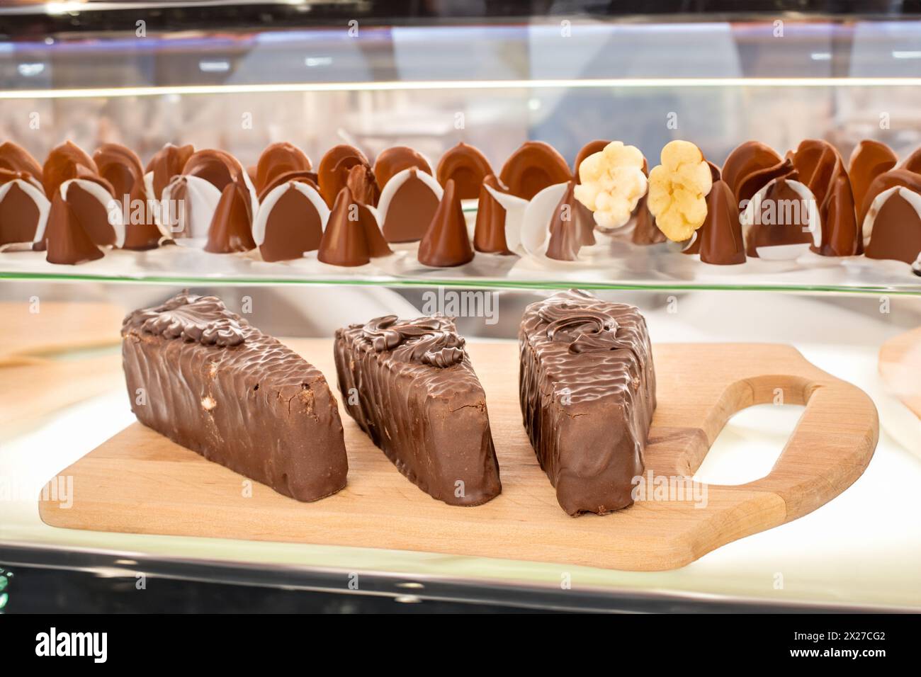 Three pieces of chocolate waffle cake on a wooden tray near a pastry ...