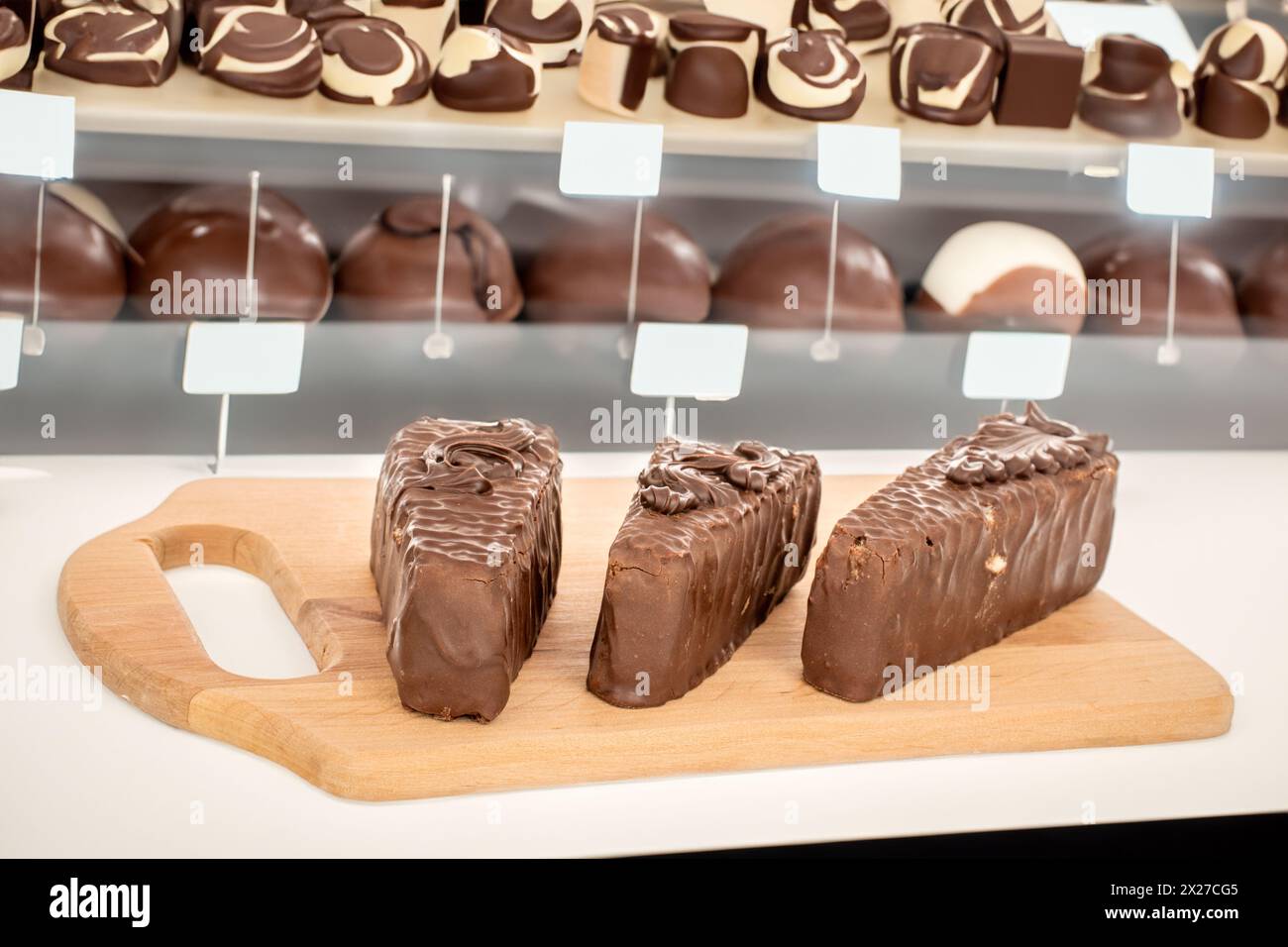 Three pieces of chocolate waffle cake on a wooden tray near a pastry ...