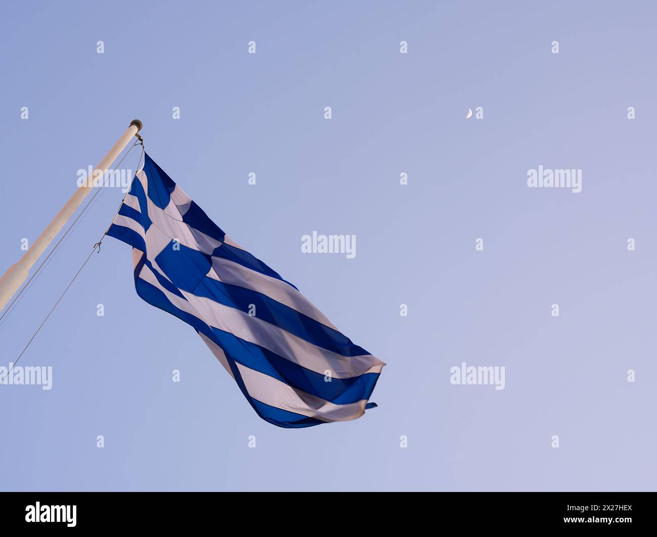 Greek flag blowing in the wind with the moon in the back under sunset ...