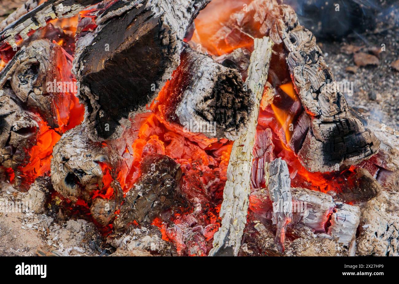 scorched wood and glowing coal in the fire. orange glowing coal ...