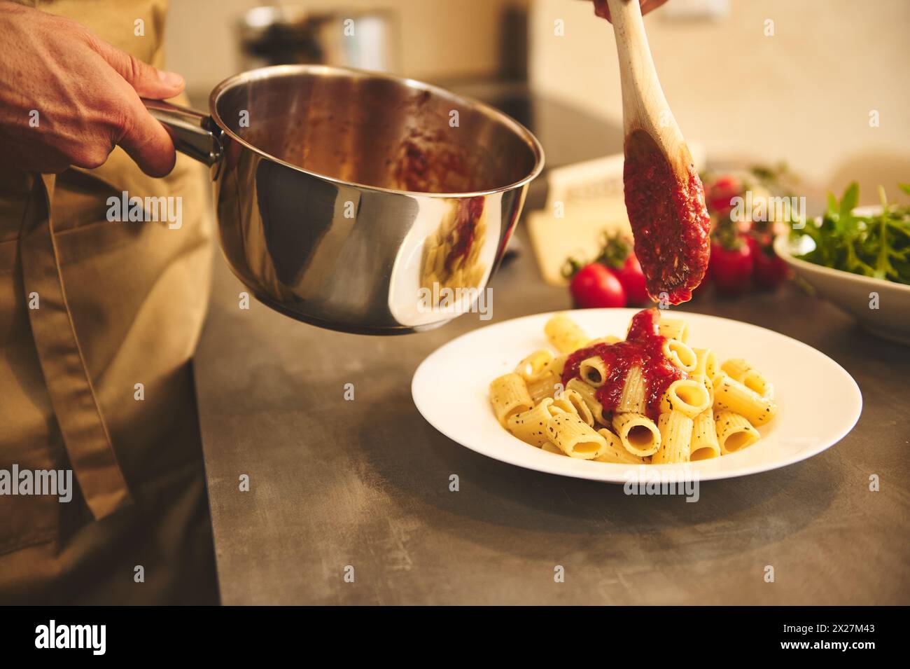Close up of professional chef plating up pasta before serving it to the ...