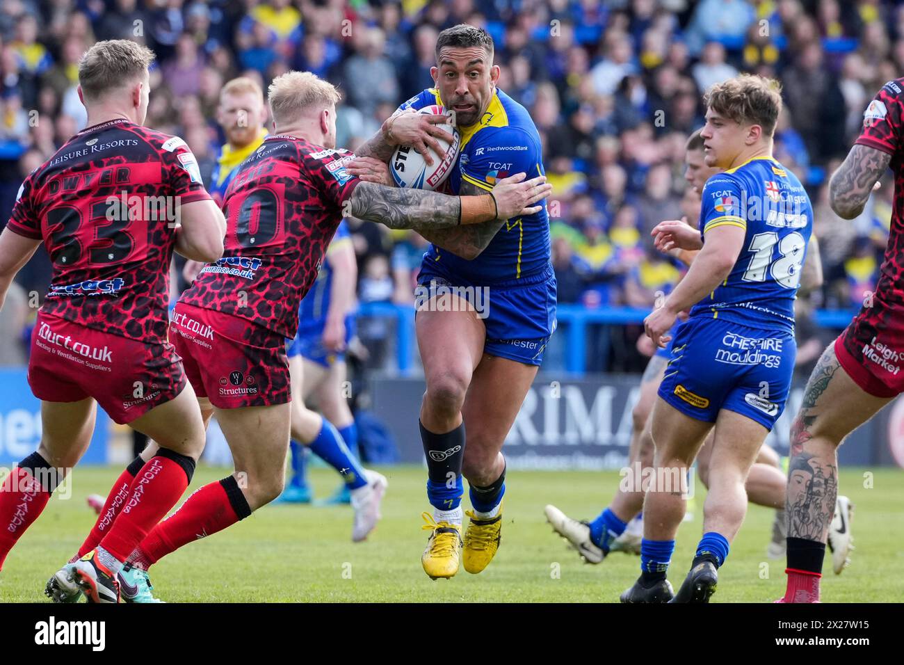 Paul Vaughan of Warrington Wolves runs through Oliver Holmes of Leigh ...