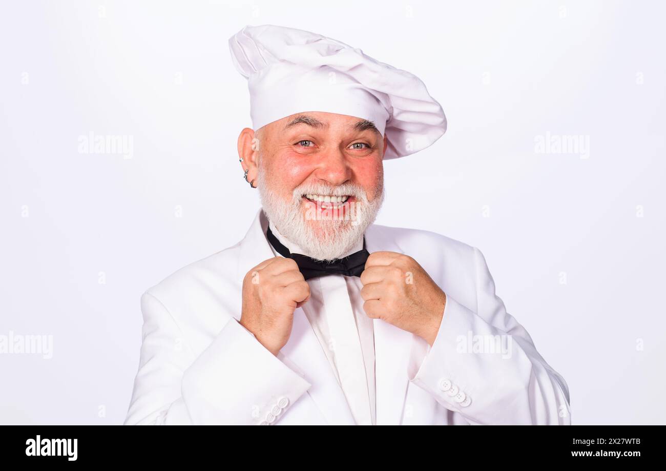 Smiling chef, cook or baker in uniform and chef hat in kitchen ...