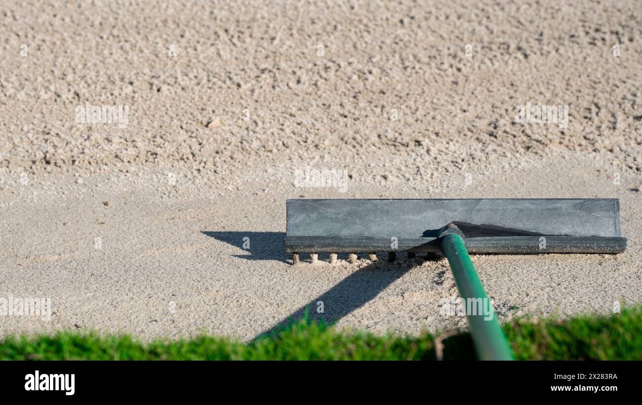 Rake in the sand trap on a golf course Stock Photo - Alamy