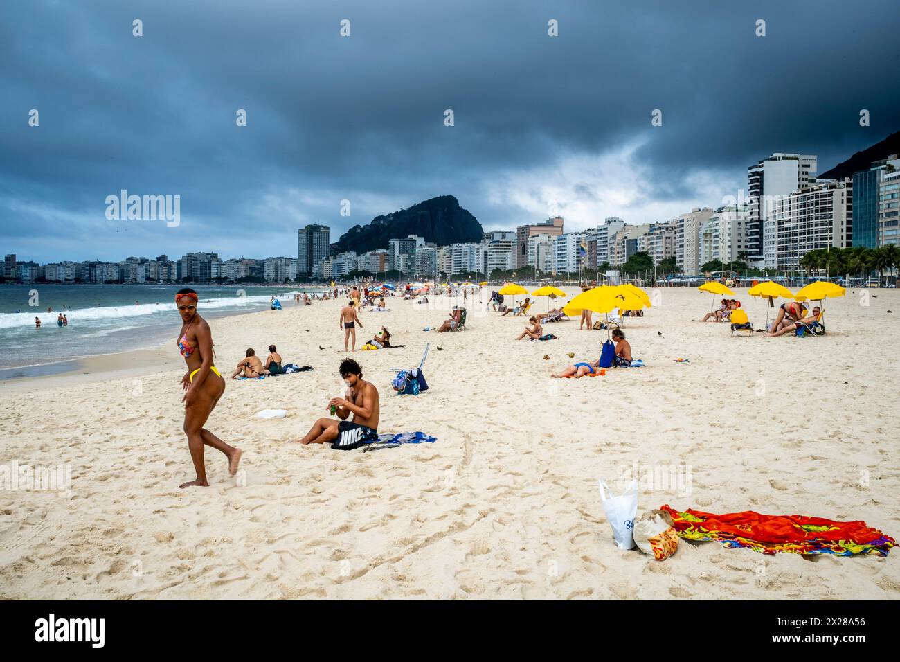 A Woman Checks Her Belongings As She Goes For A Swim On Copacabana ...