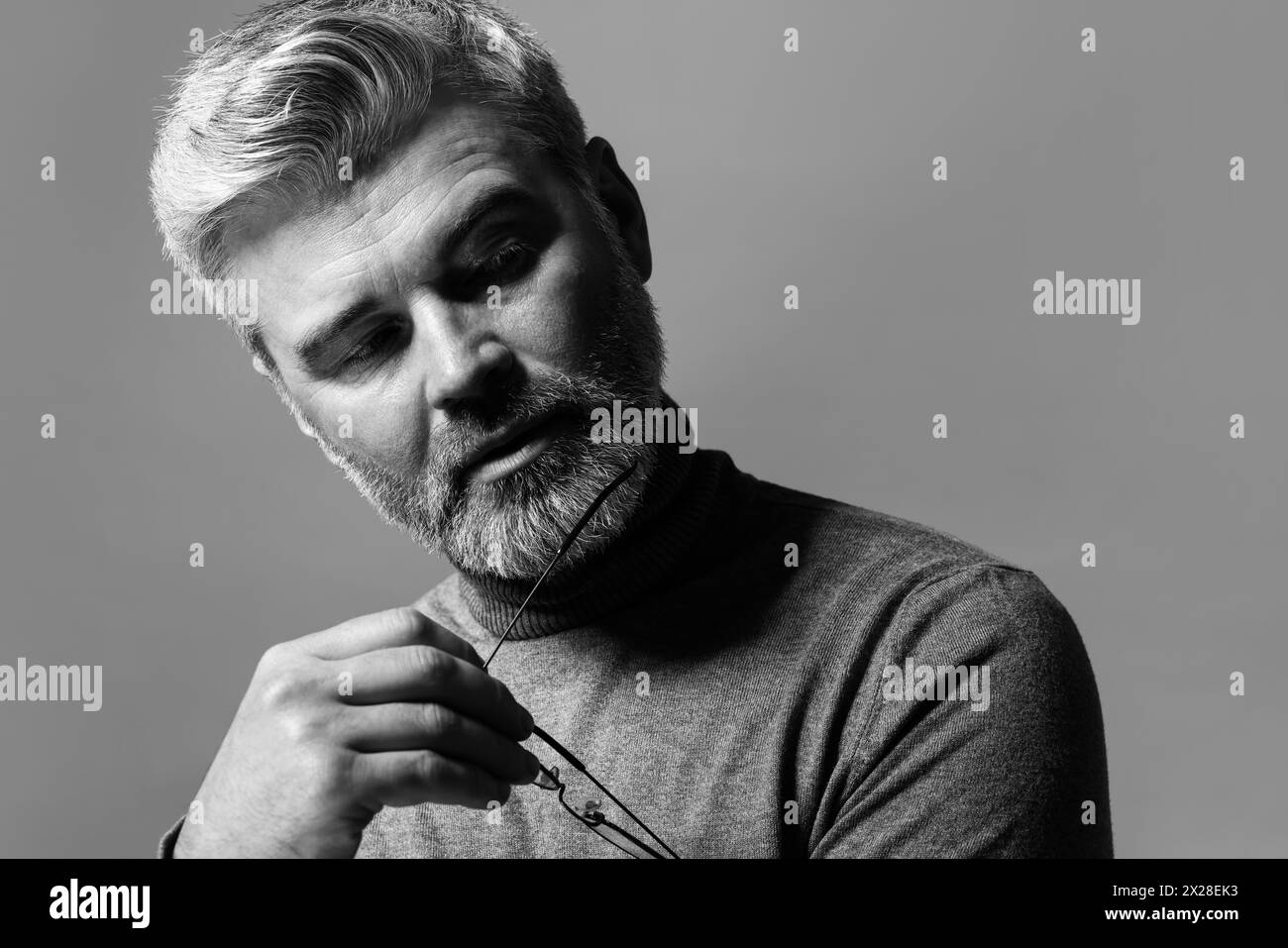 Portrait of handsome man on grey background. Black and white effect ...