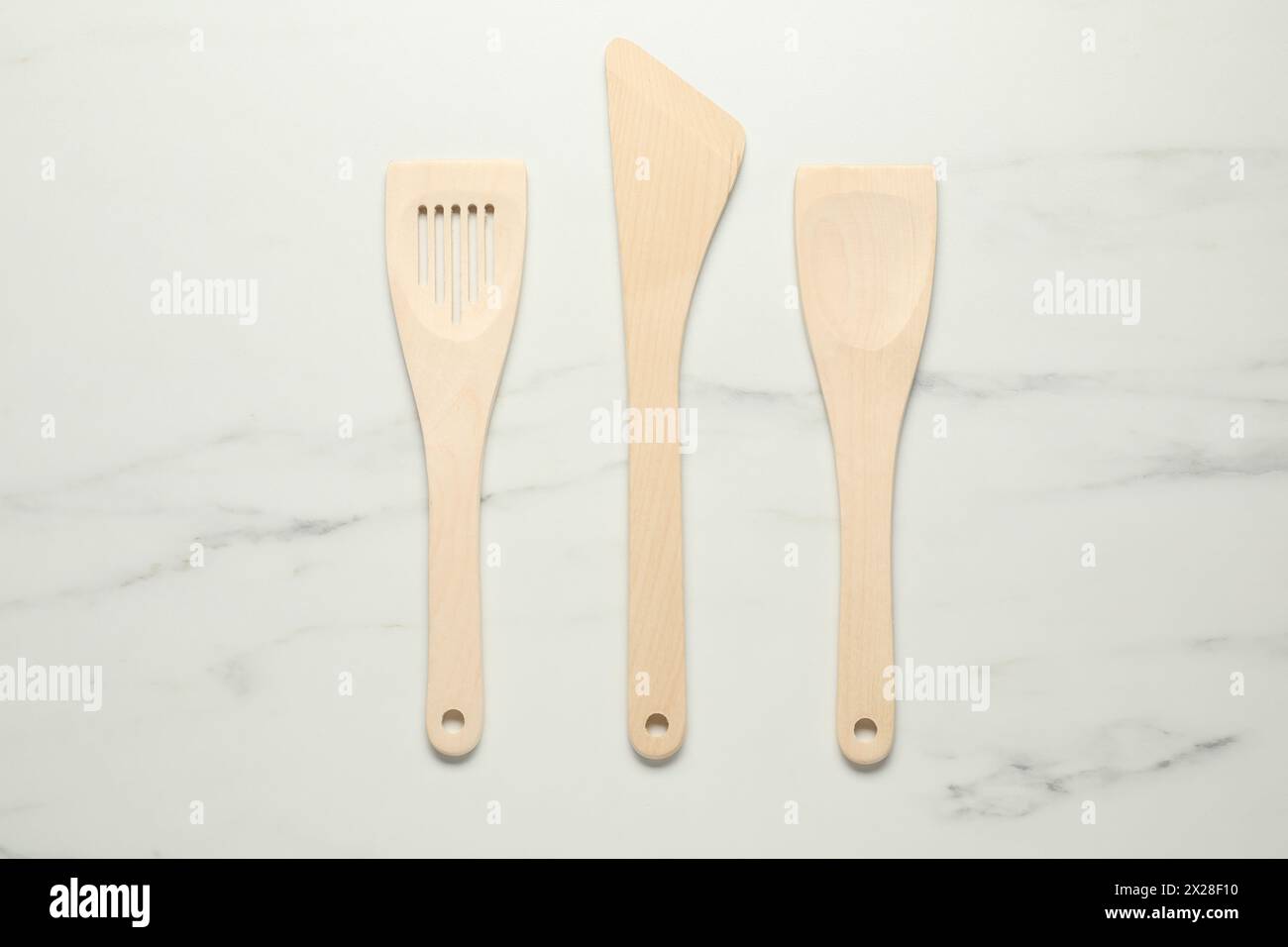 Different wooden spatulas on white marble table, flat lay Stock Photo ...