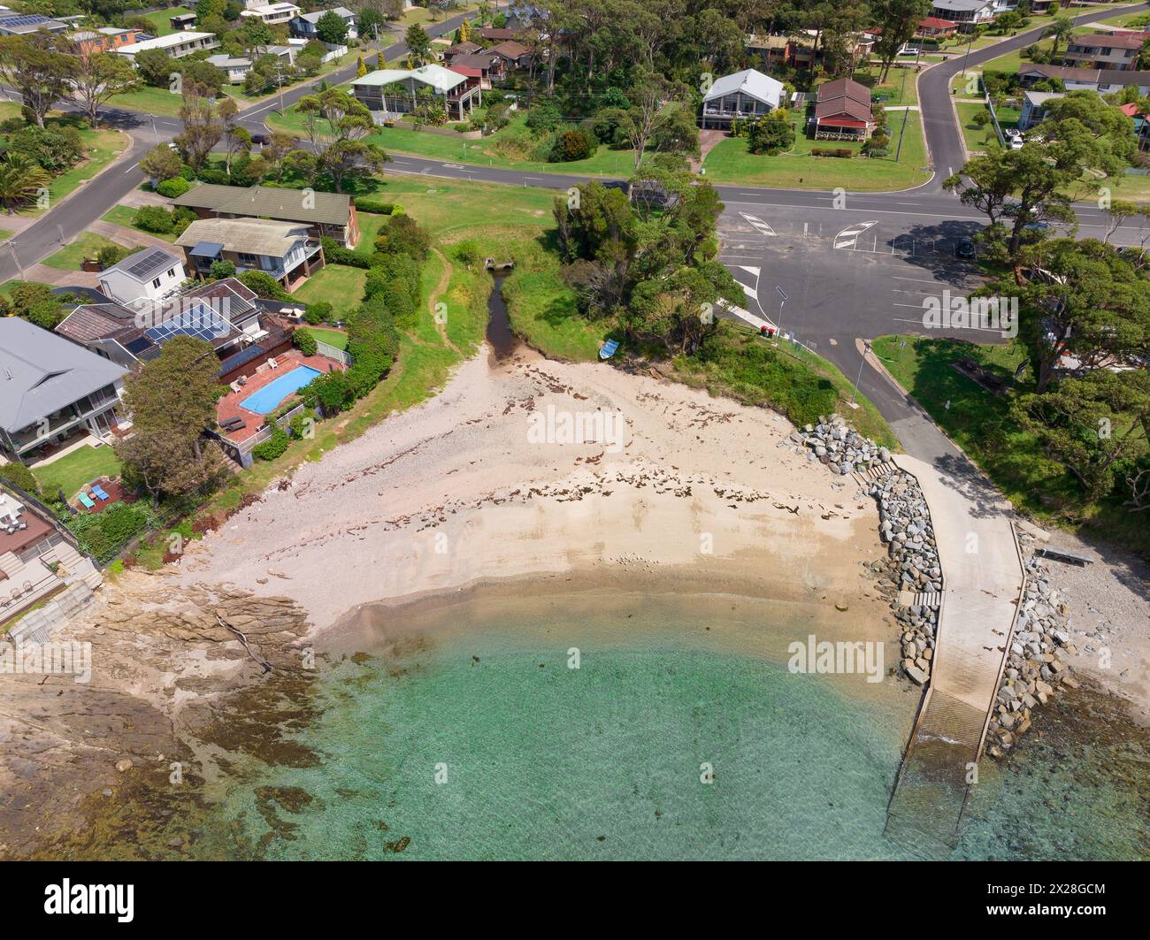 Aerial view of a boat ramp alongside a small sandy beach in a sheltered ...