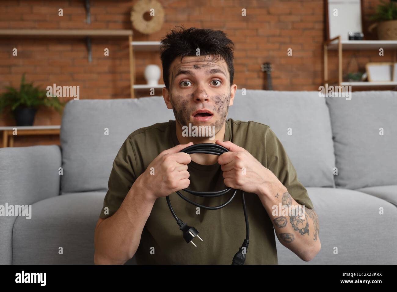 Electrocuted young man with burnt face and plug at home Stock Photo - Alamy