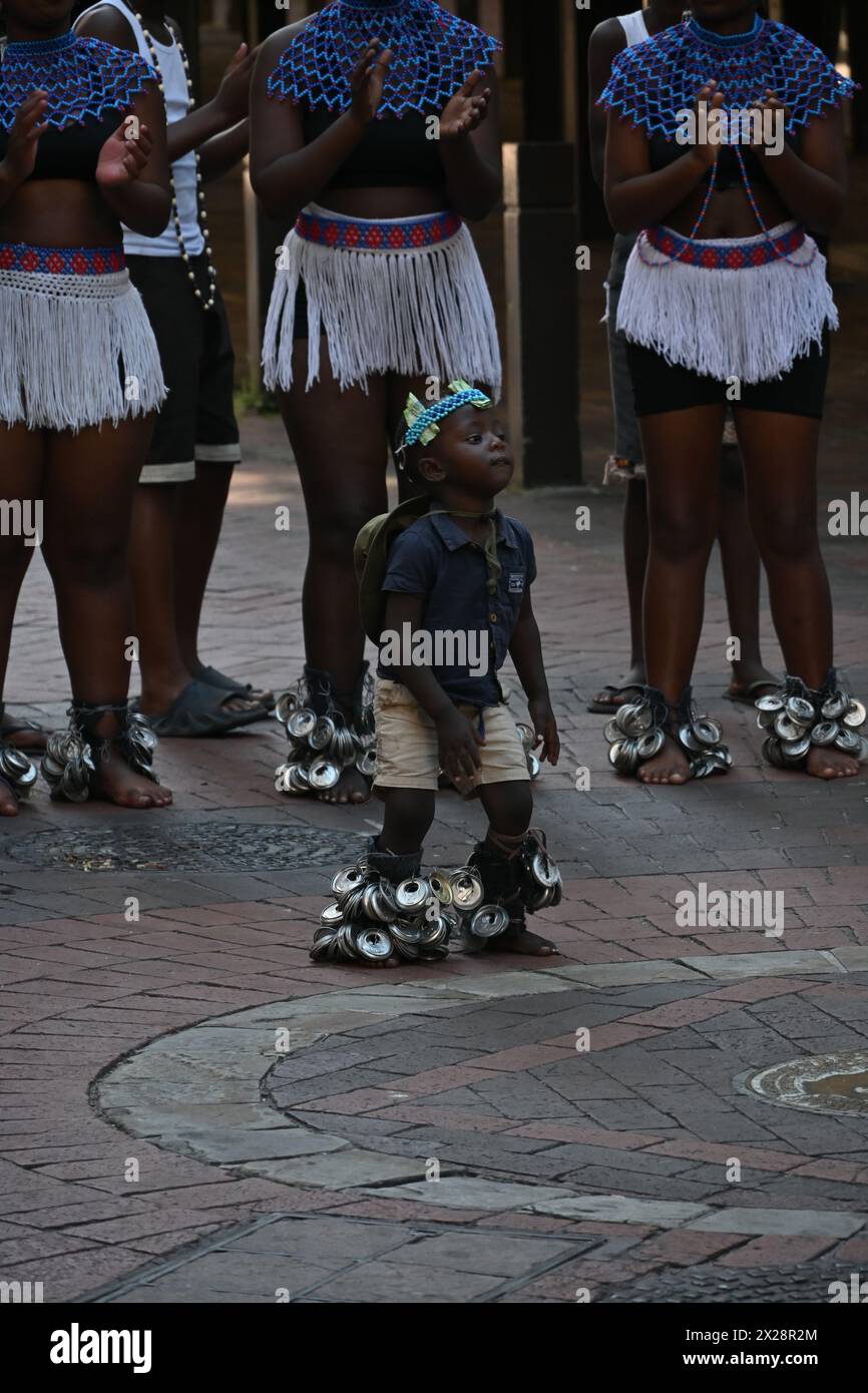 A little black kid in local costume performing a typical african dance ...